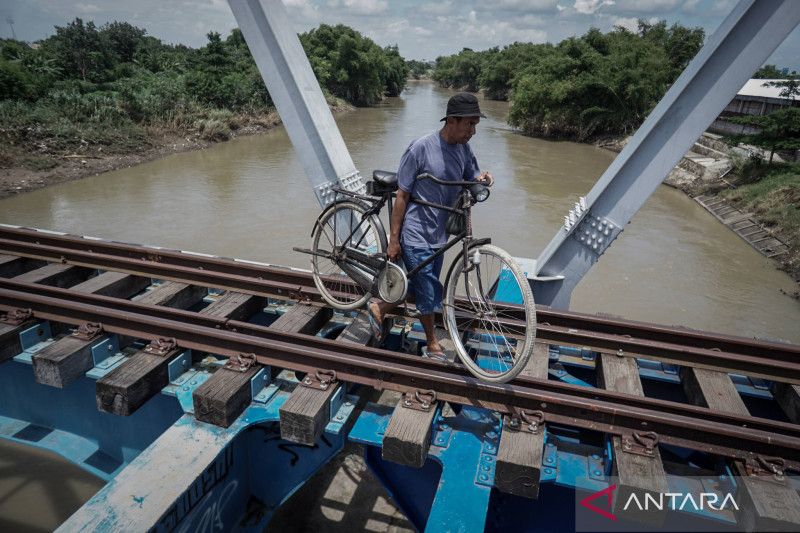 Warga seberangi Bengawan Solo lewat jembatan jalur rel kereta api ...